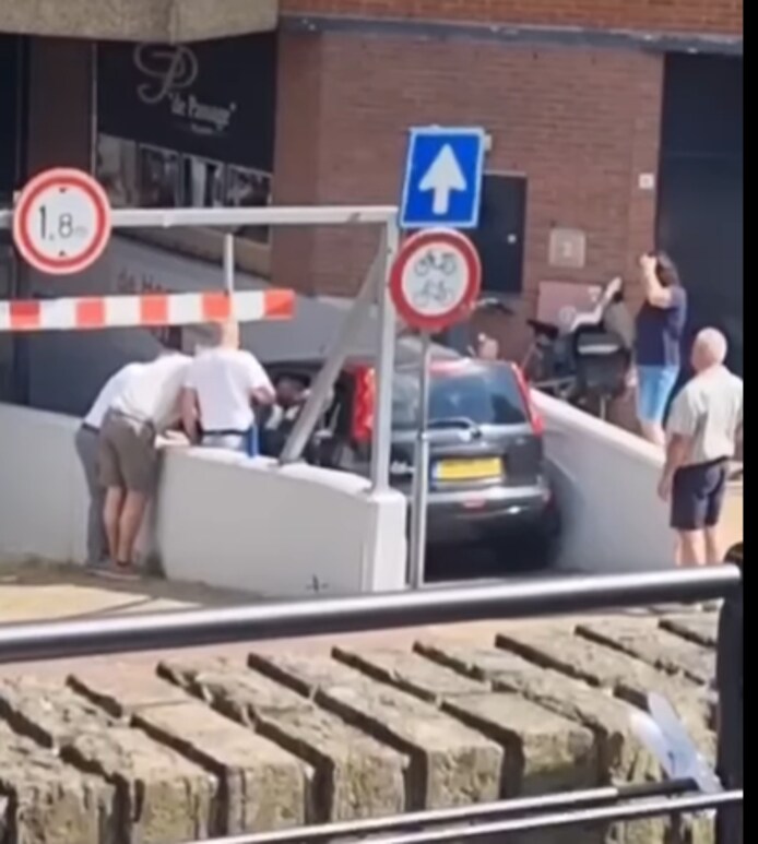 Bestuurder kiest verkeerde inrit bij parkeergarage en zit muurvast ...