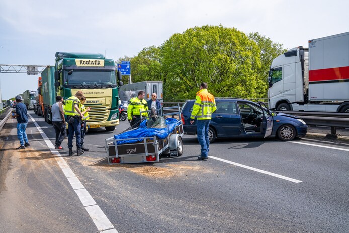 Te zwaar beladen auto met aanhanger komt dwars op A67 terecht, asfalt ...