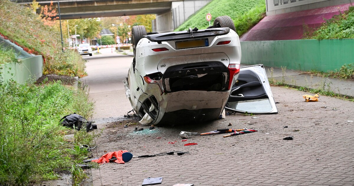 Auto rijdt van viaduct en landt ondersteboven op straat, mannen (21 en ...