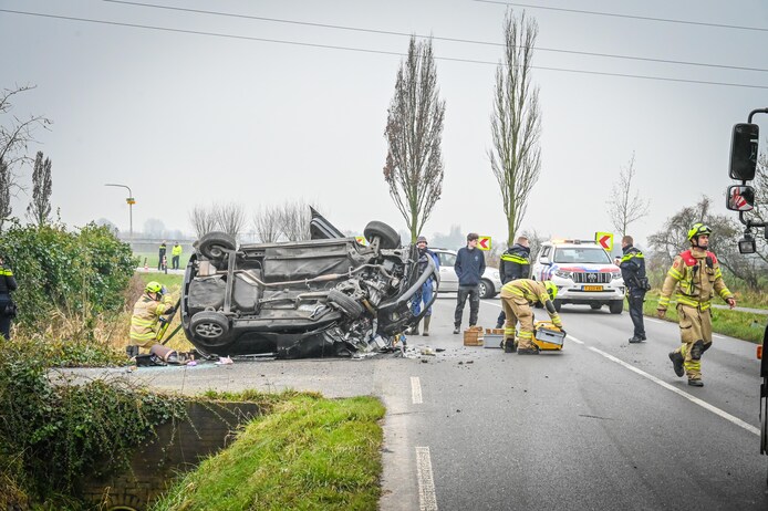 Auto slaat in bocht van beruchte weg over de kop, brandweer moet bestuurder bevrijden uit wrak ...