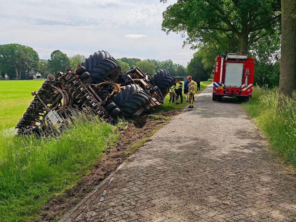 Groot landbouwvoertuig belandt op de kop in sloot: boer trapt voorruit ...