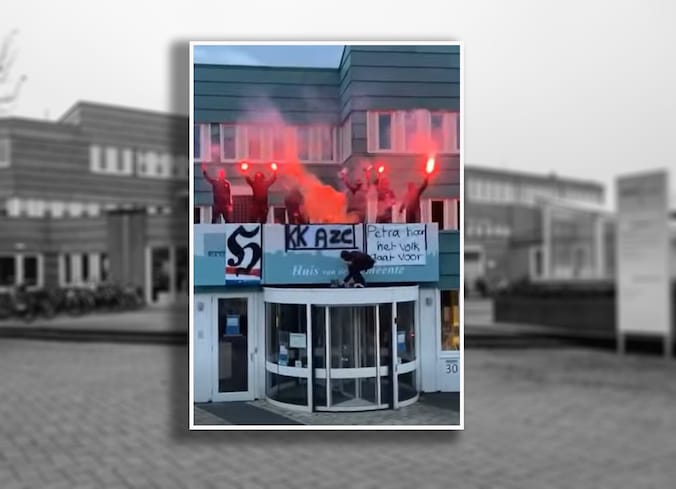 Gemaskerde anti-azc-demonstranten klimmen met fakkels op dak stadhuis ...