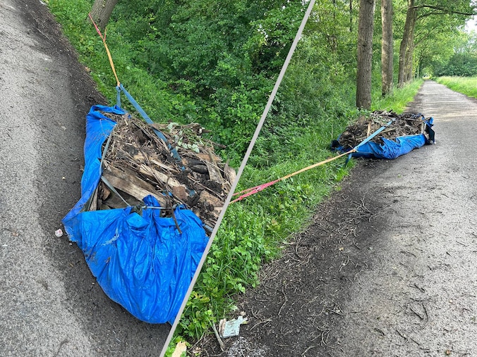 Afvaldumper bindt lading vast aan boom en rijdt weg in buitengebied van ...