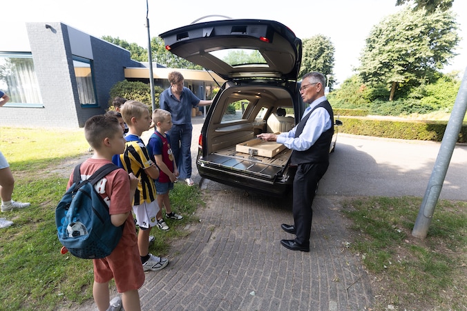 Scholieren staan oog in oog met begrafenisauto tijdens Roefeldag in ...