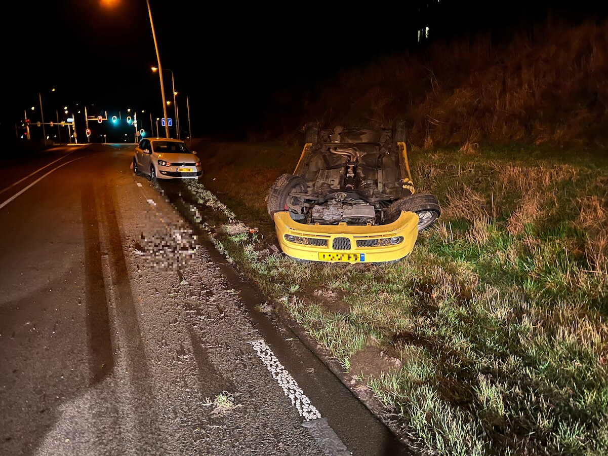 Auto slaat over de kop via geluidswal in Zutphen, bestuurder staat ...